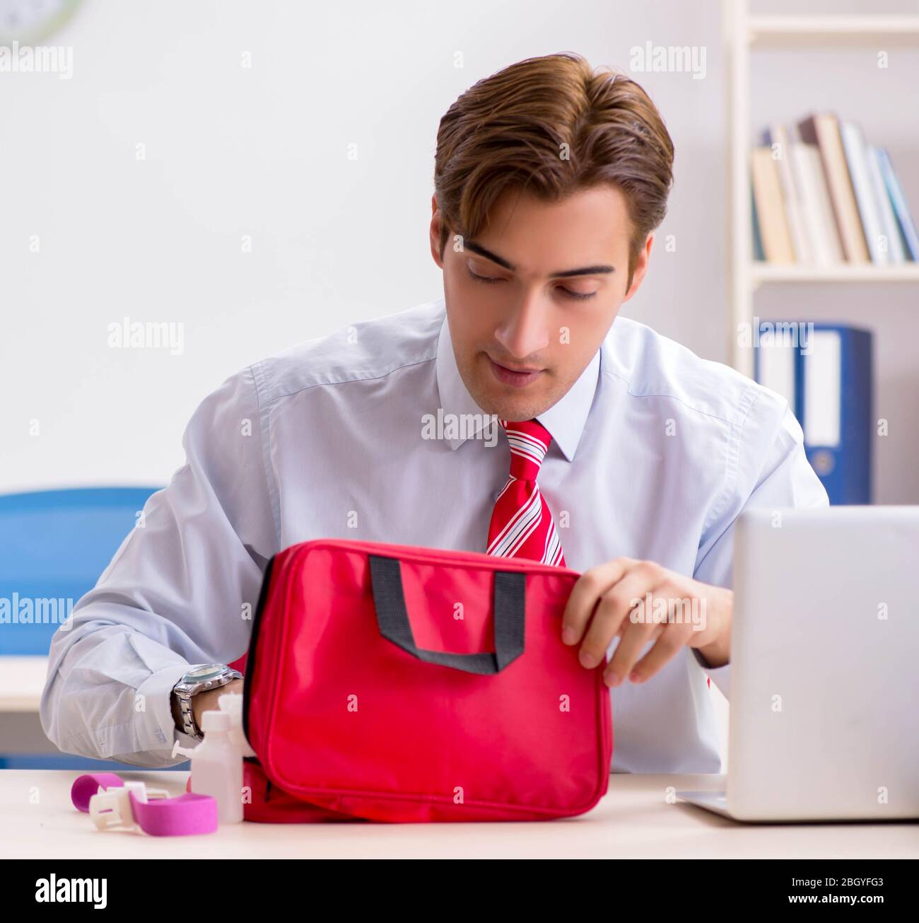 The man with first aid kit in the office Stock Photo - Alamy