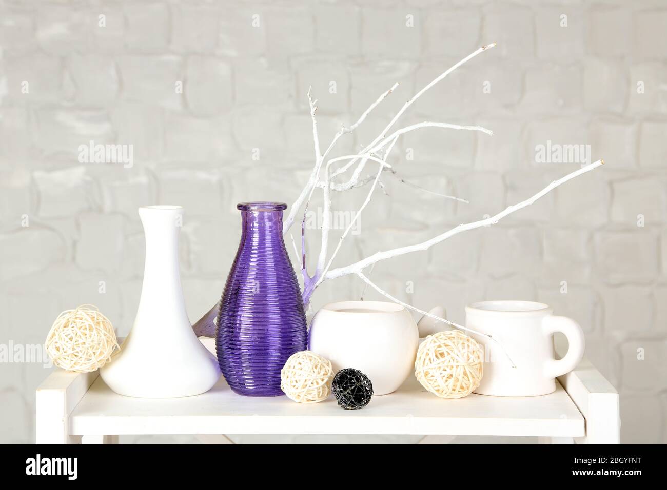 Interior with decorative vases and branch twig on table top and white ...