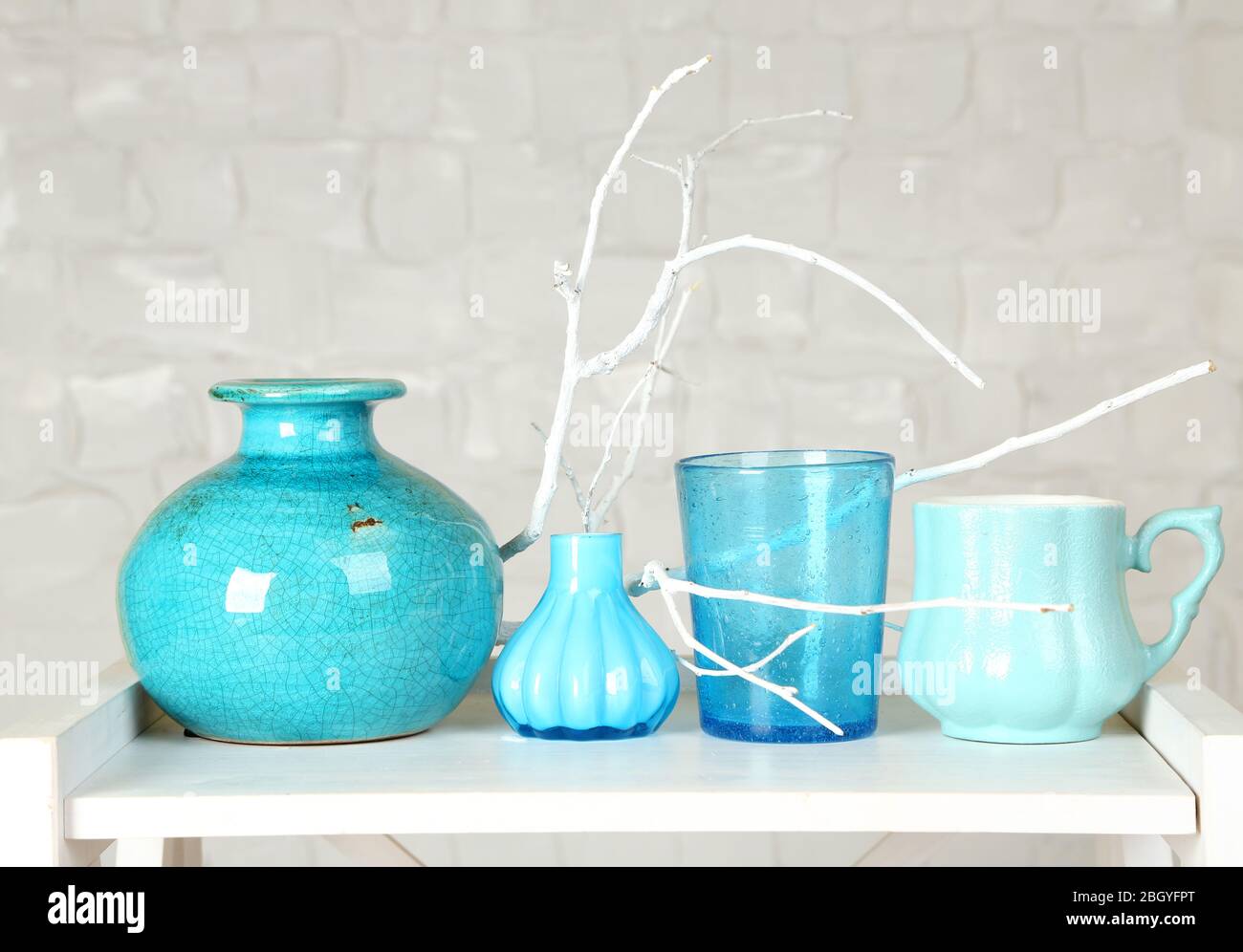 Interior with decorative vases and branch twig on table top and white ...