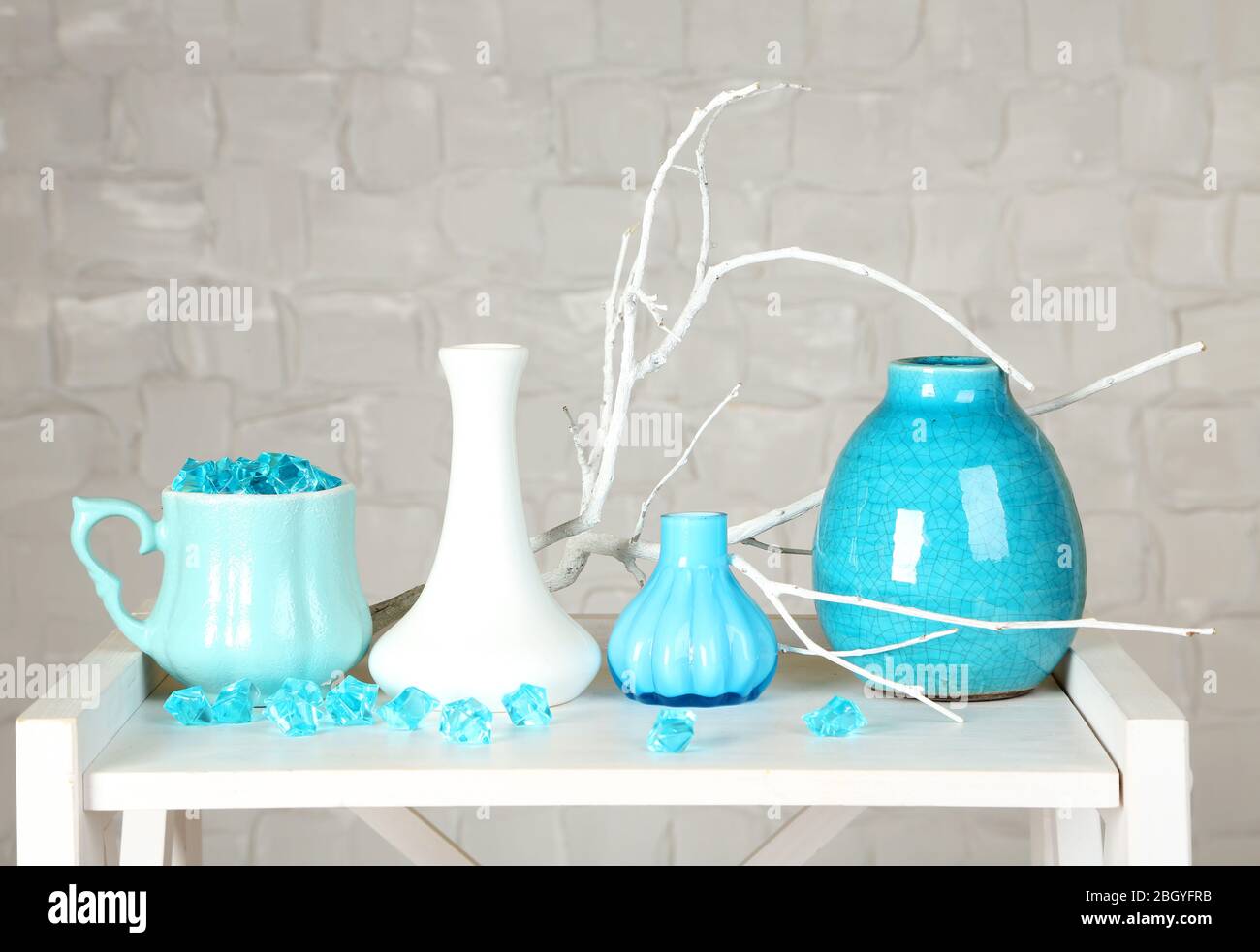 Interior with decorative vases and branch twig on table top and white ...