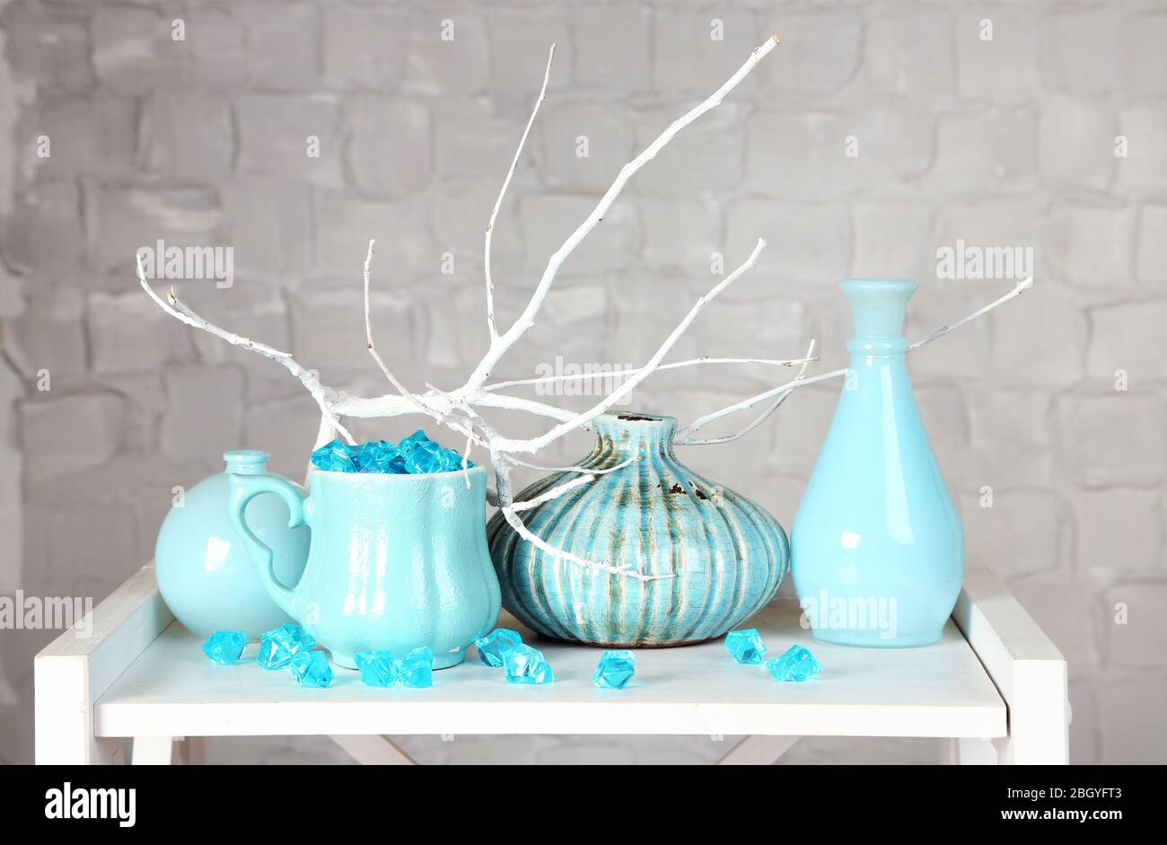 Interior with decorative vases and branch twig on table top and white ...