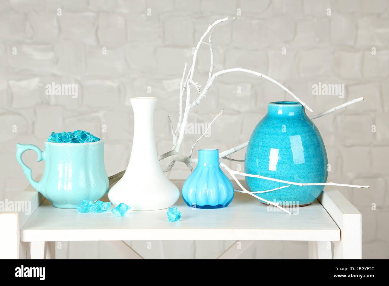 Interior with decorative vases and branch twig on table top and white ...