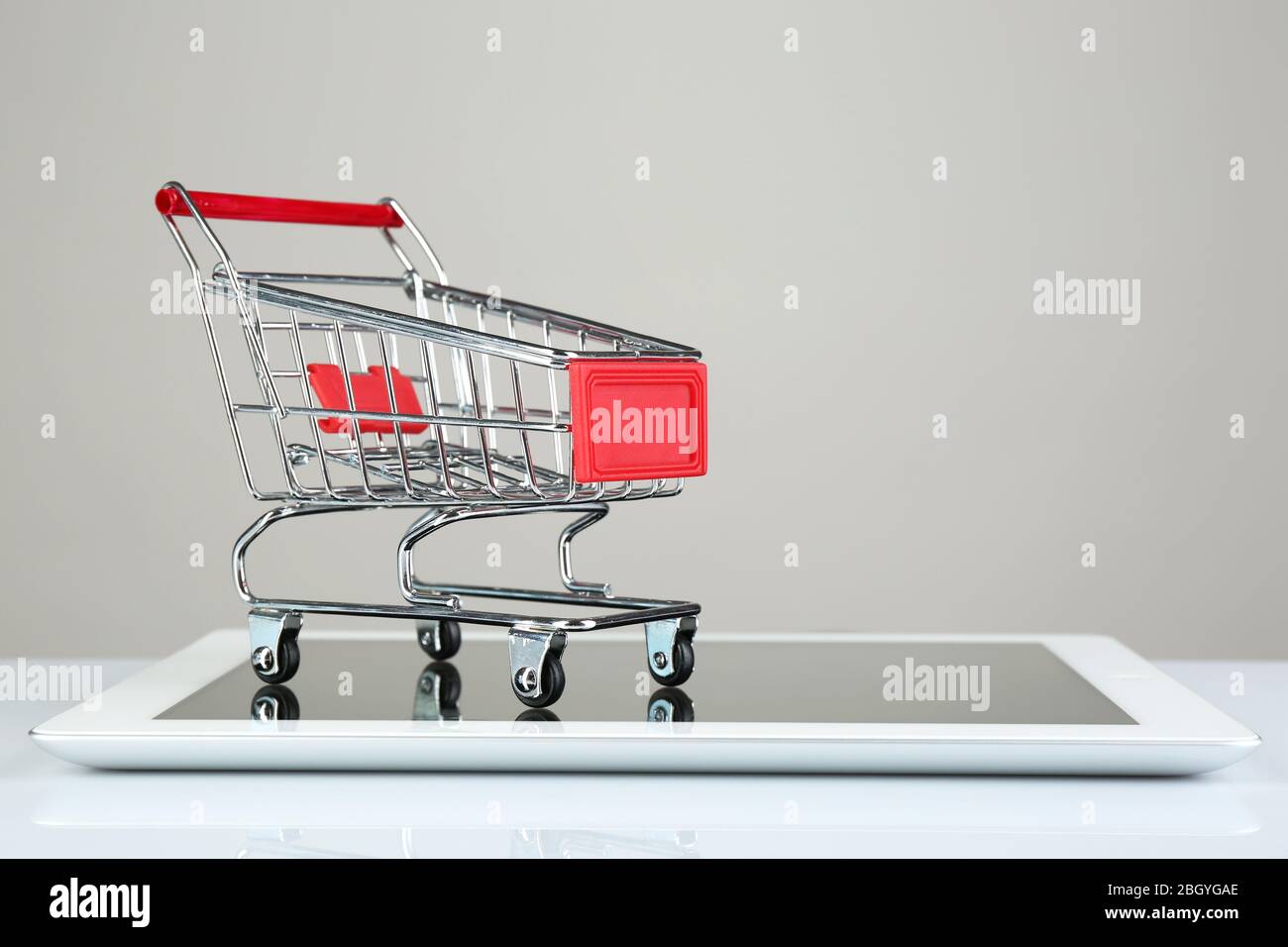 Tablet with small shopping cart isolated on white background Stock ...