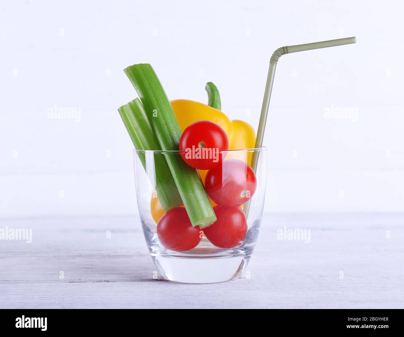 Vegetables in glass with tube on color wooden planks background Stock ...