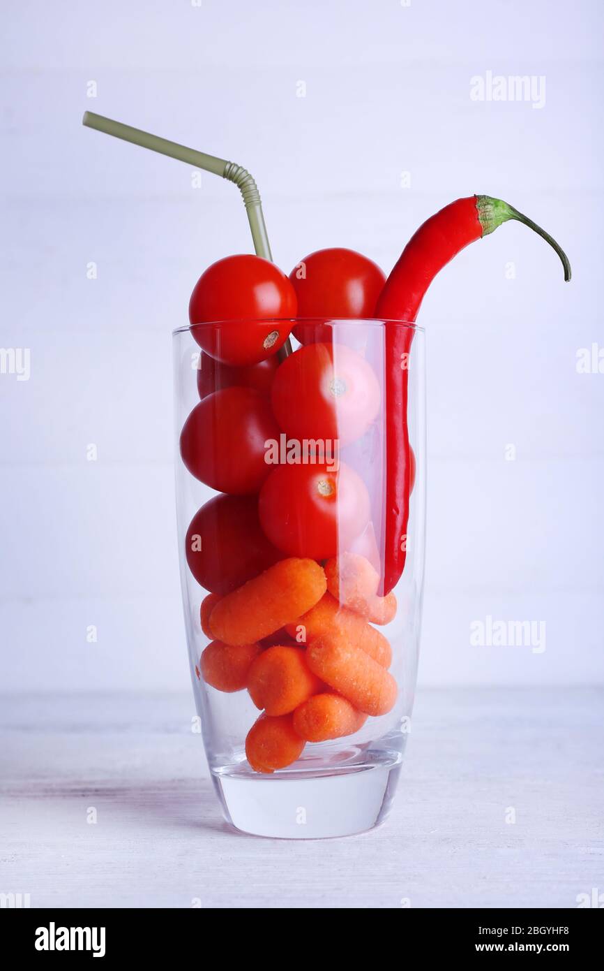 Vegetables in glass with tube on color wooden planks background Stock ...