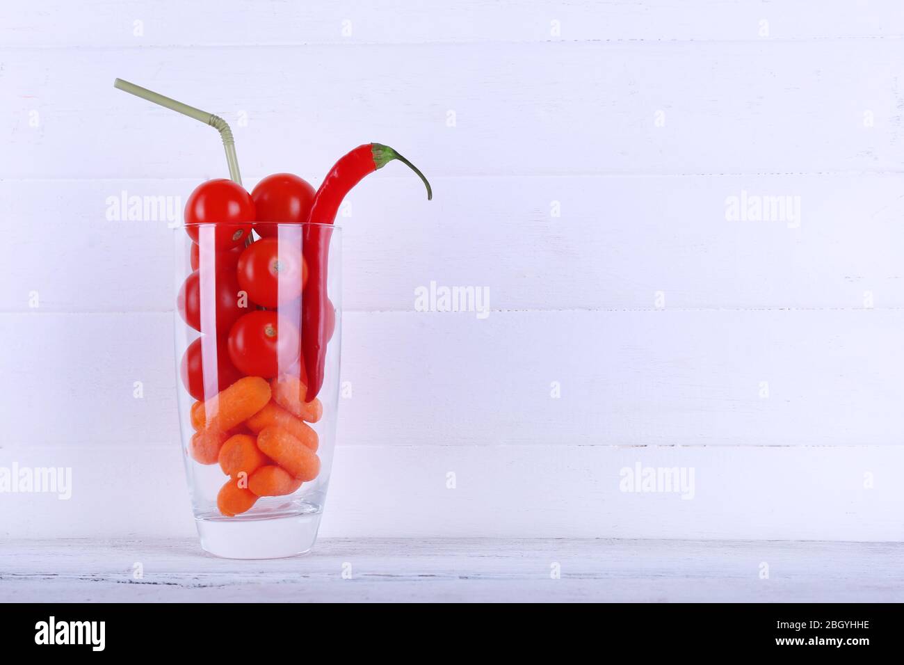 Vegetables in glass with tube on color wooden planks background Stock ...