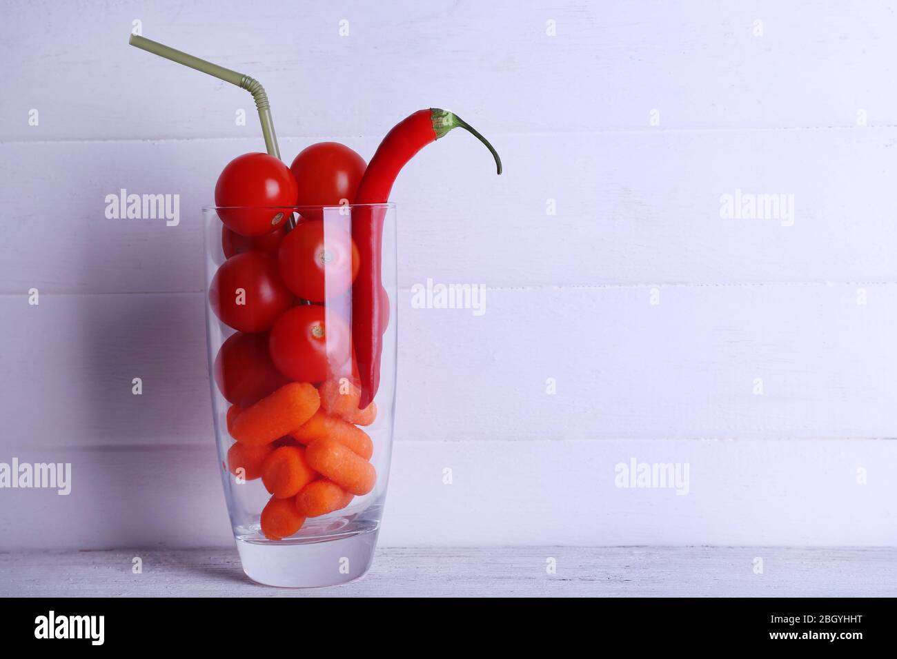 Vegetables in glass with tube on color wooden planks background Stock ...
