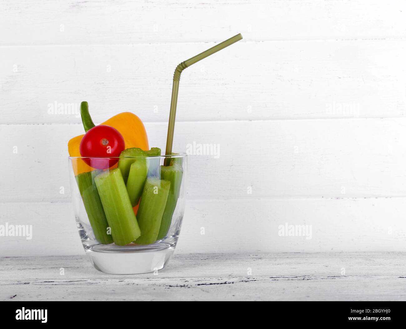 Vegetables in glass with tube on color wooden planks background Stock ...