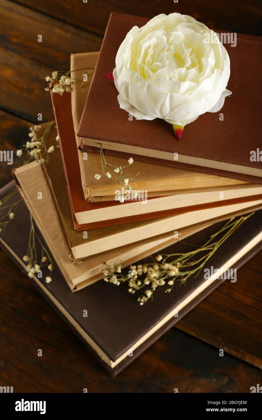 Books with flower on wooden background Stock Photo - Alamy