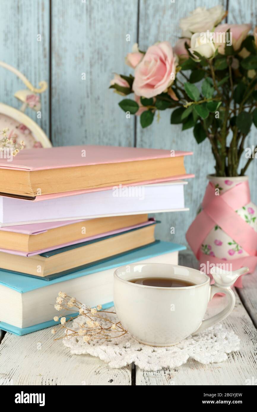 Cup of tea with books and flowers on wooden background Stock Photo - Alamy