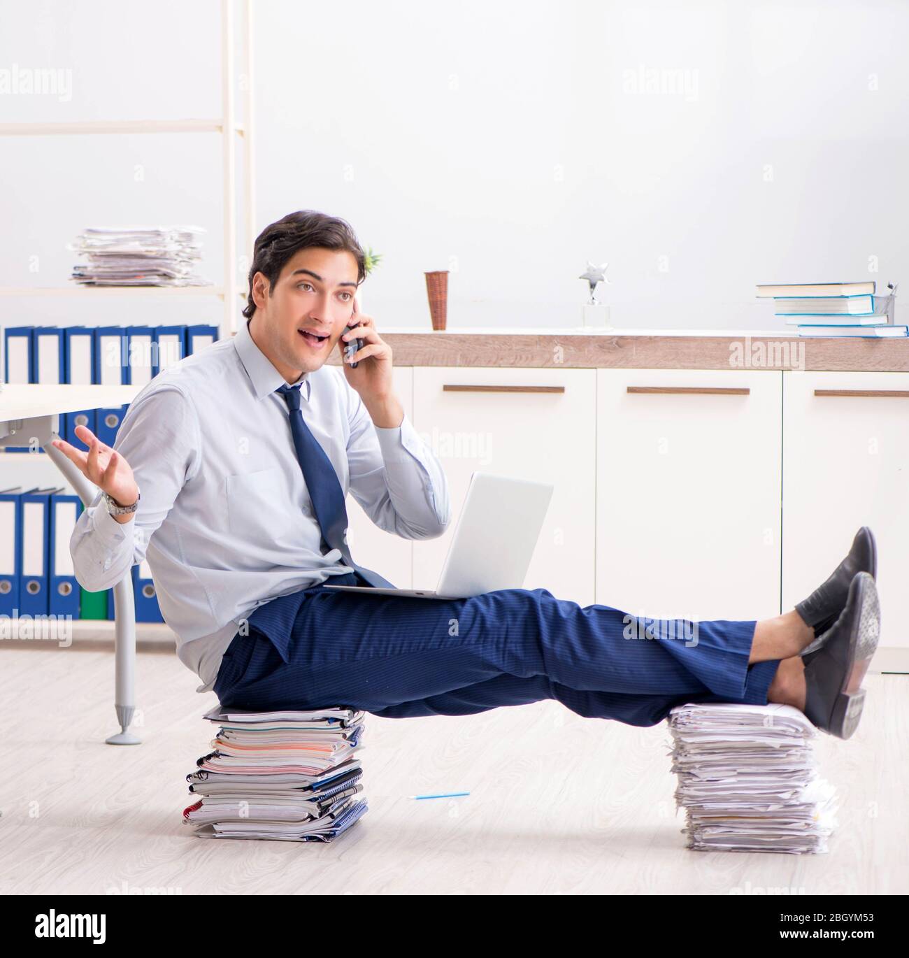 The extremely busy employee working in the office Stock Photo - Alamy