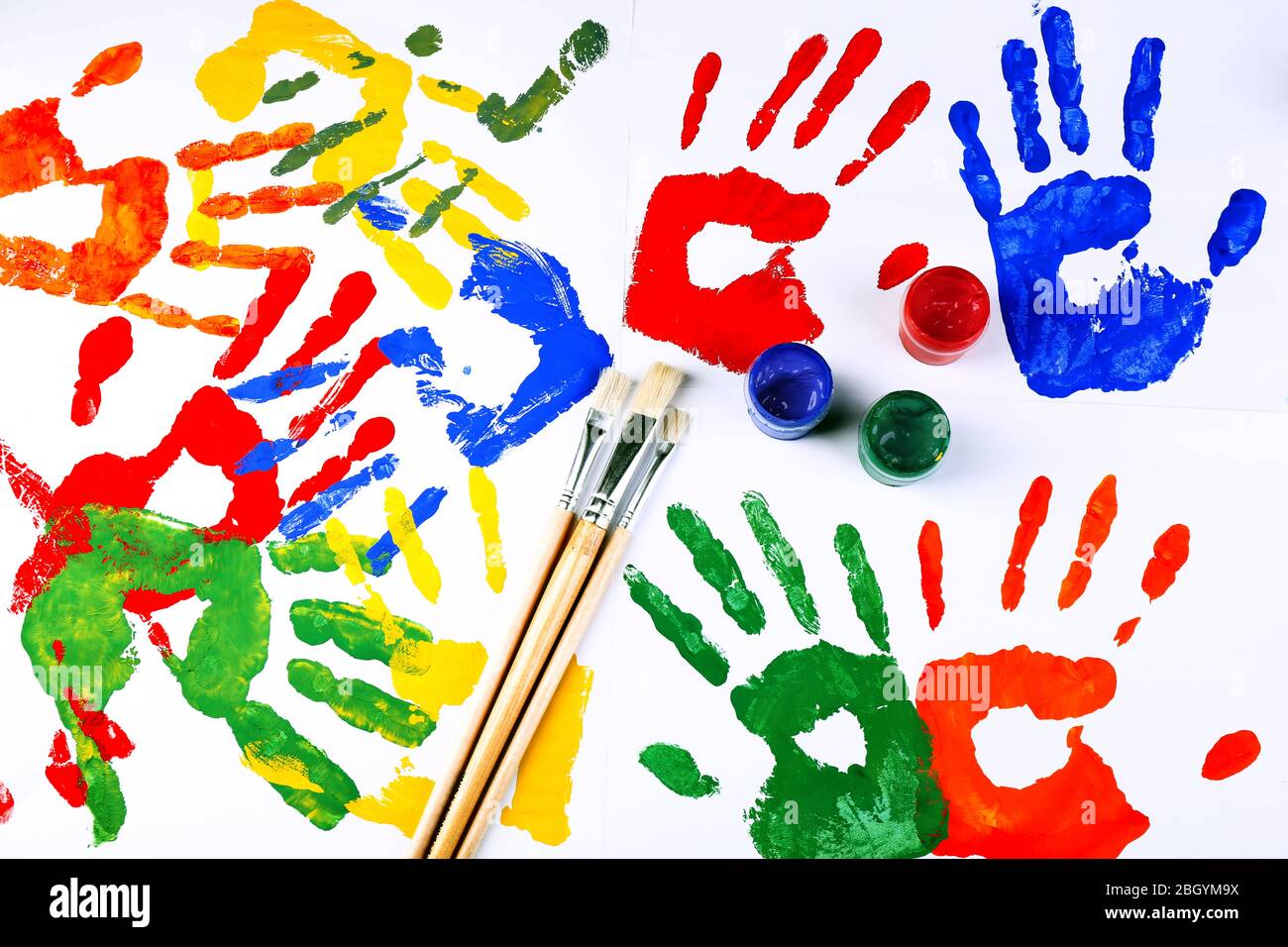 Hand prints of paint, paints and brushes on white background Stock ...