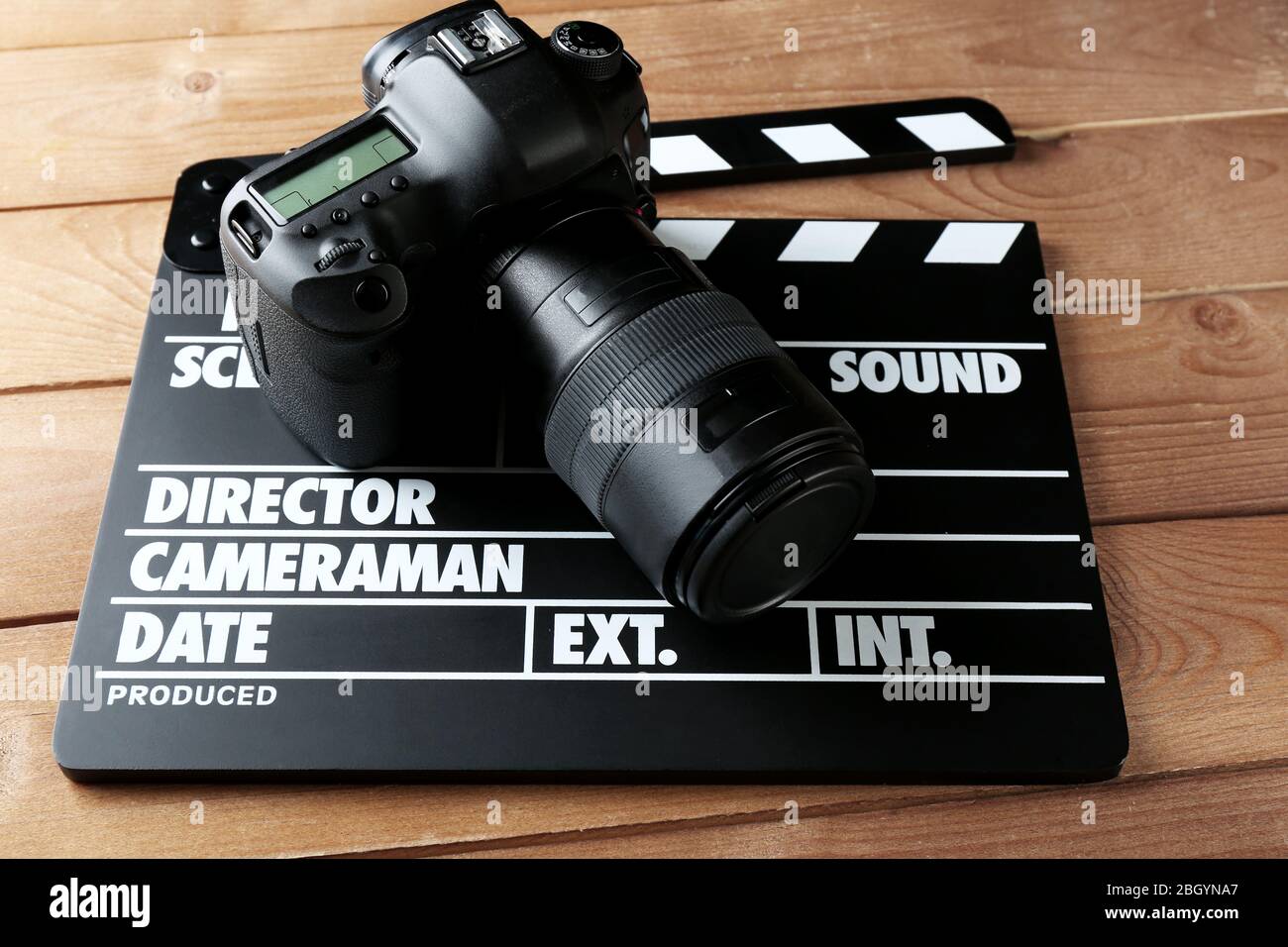 Photo camera and movie clapper on wooden background Stock Photo - Alamy