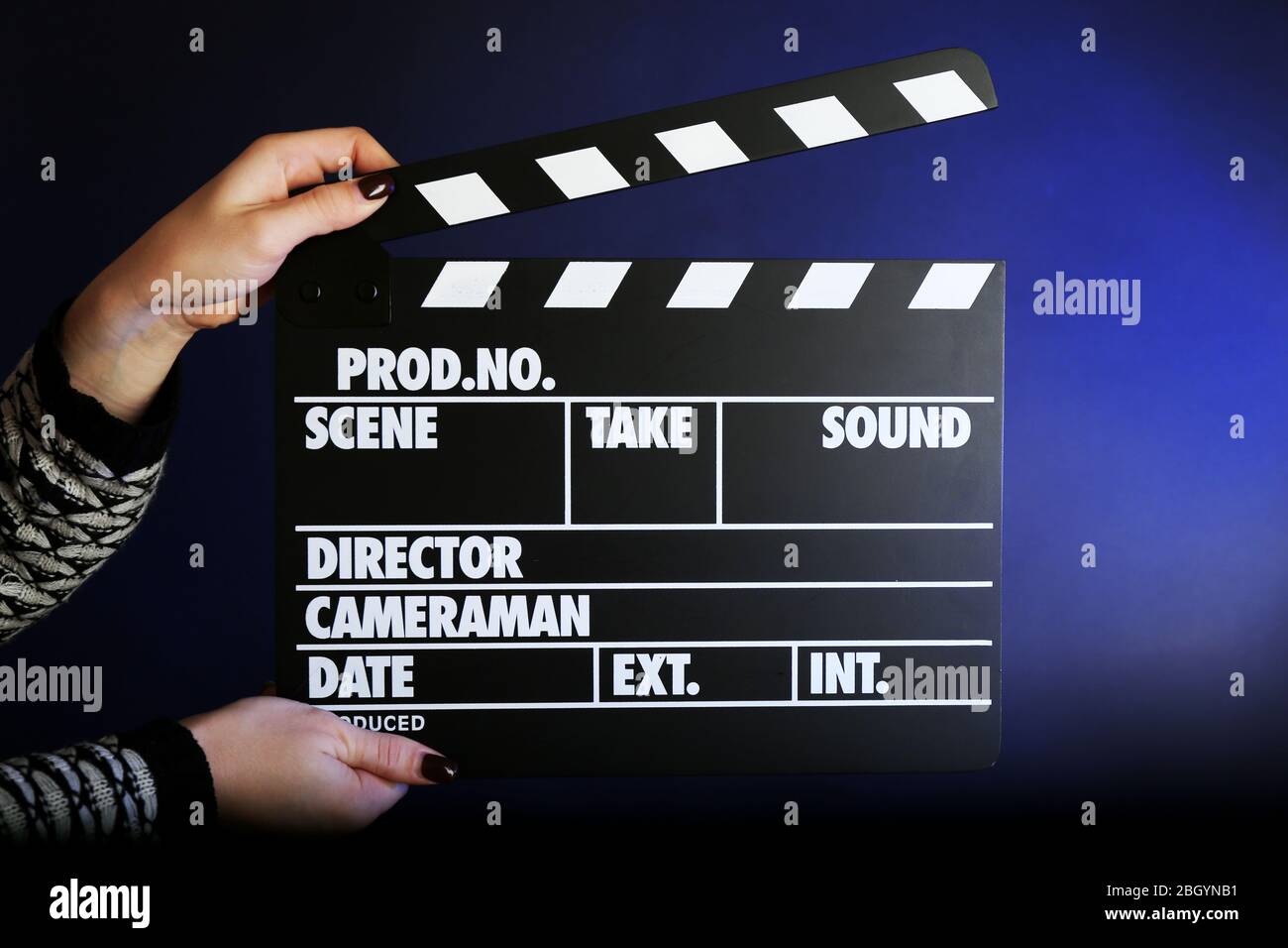 Movie clapper in female hand on dark color background Stock Photo - Alamy