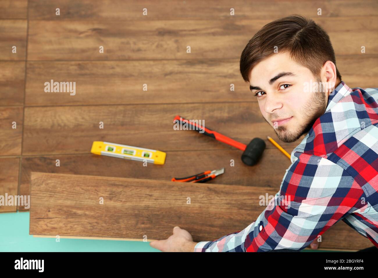 Carpenter worker installing laminate flooring in the room Stock Photo ...