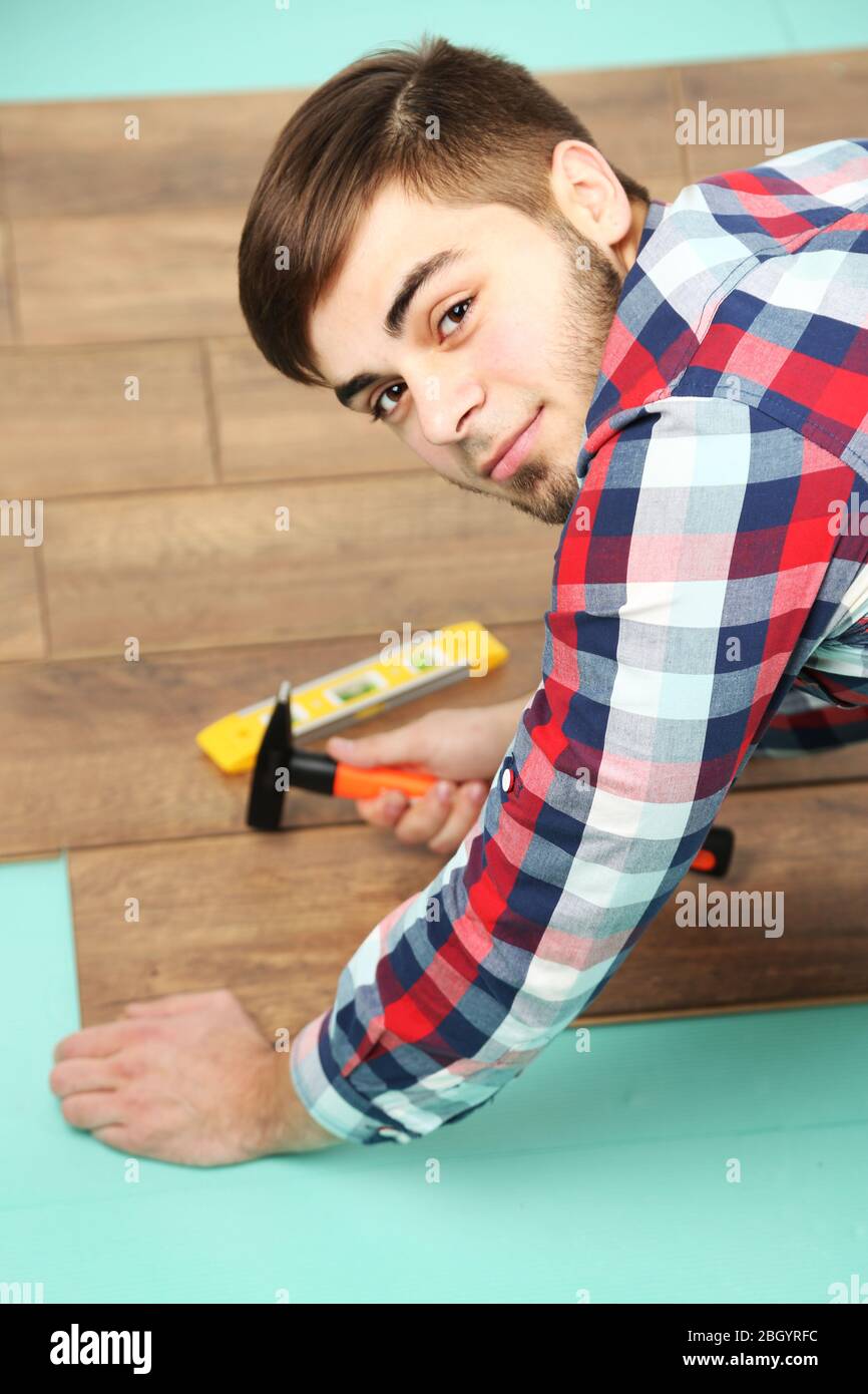 Carpenter worker installing laminate flooring in the room Stock Photo ...