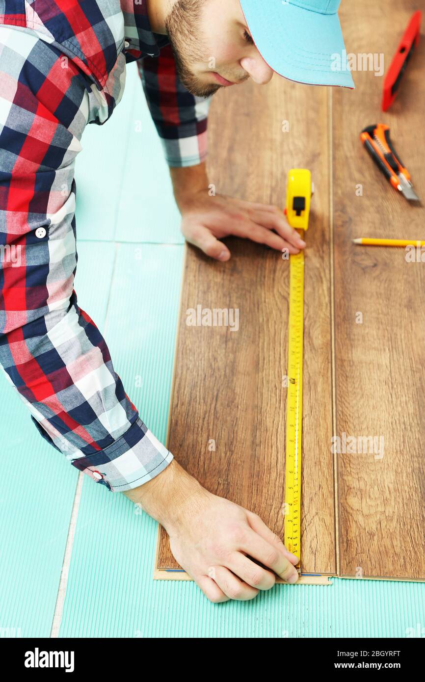 Carpenter worker installing laminate flooring in the room Stock Photo ...