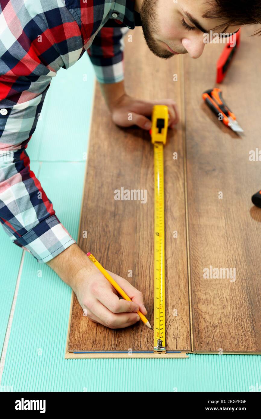 Carpenter worker installing laminate flooring in the room Stock Photo ...