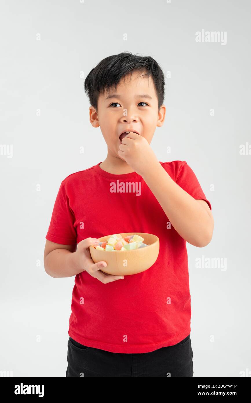 Cute little boy smiling and holding a bowl of candy Stock Photo - Alamy