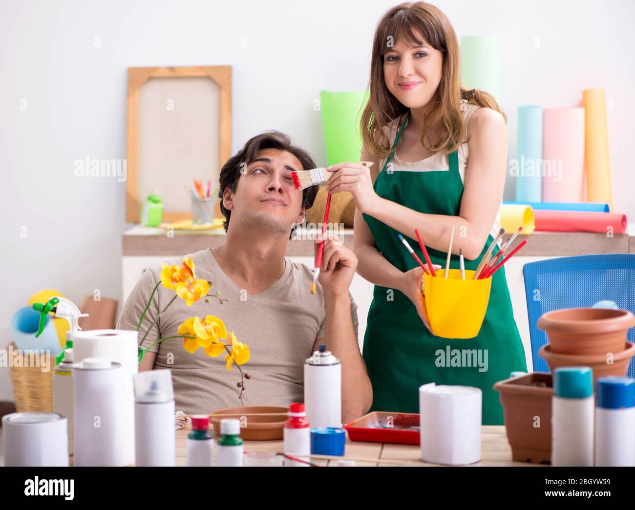 The couple decorating pots in workshop during class Stock Photo - Alamy