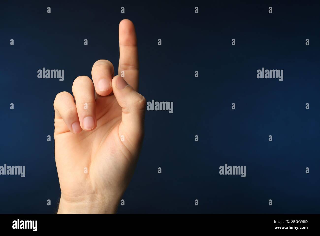 Male hand pointing up on dark blue background Stock Photo - Alamy