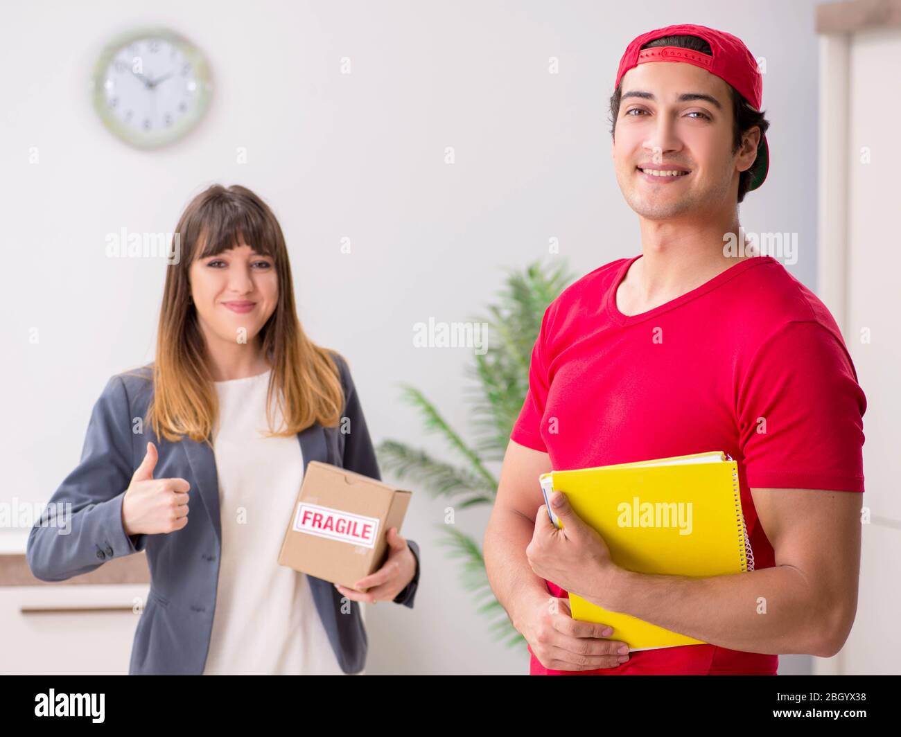The courier delivering parcel to the office Stock Photo - Alamy