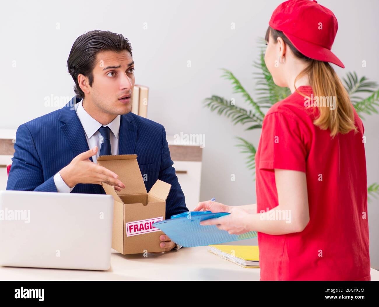The courier delivering parcel to the office Stock Photo - Alamy