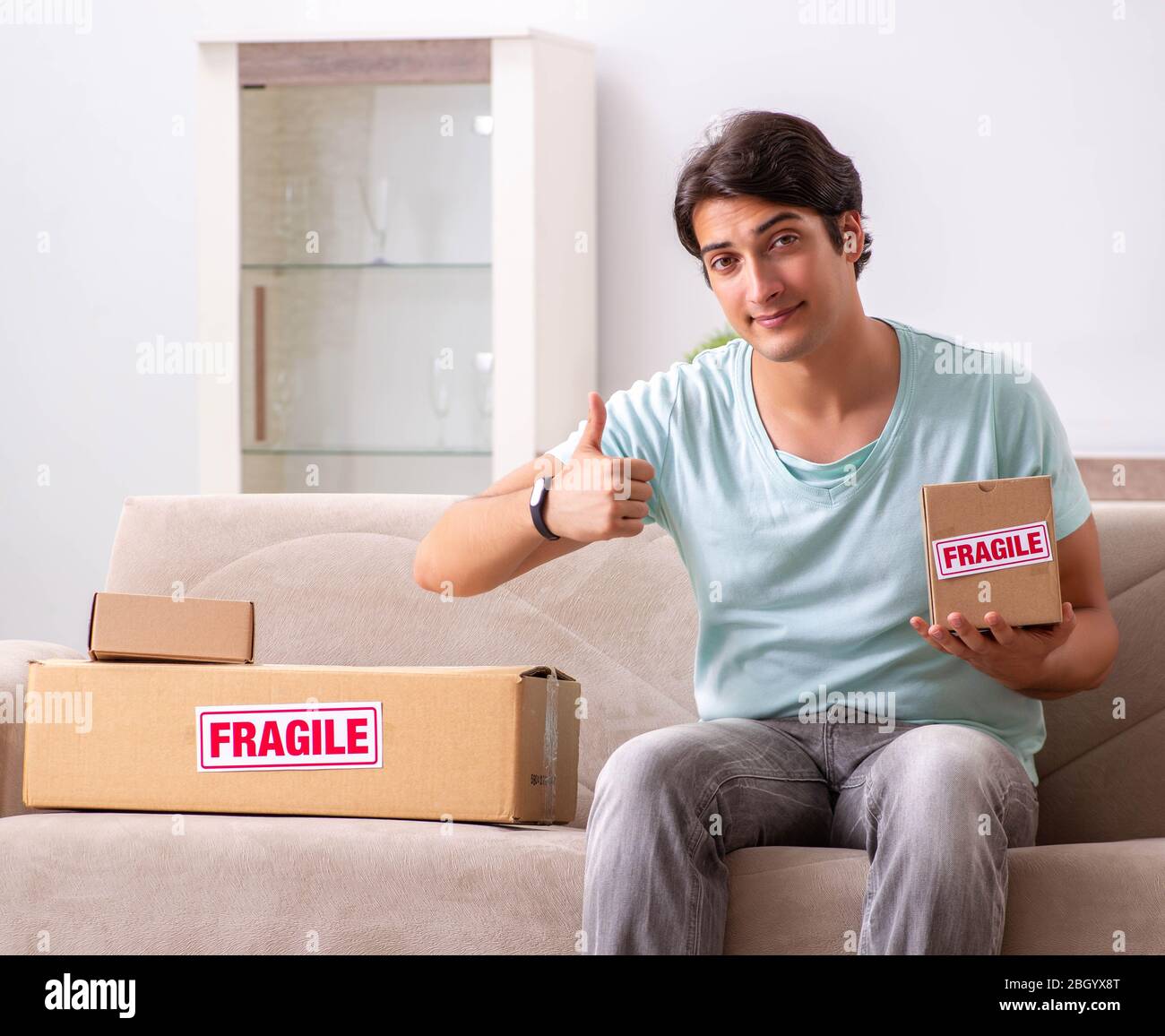 The man opening fragile parcel ordered from internet Stock Photo - Alamy