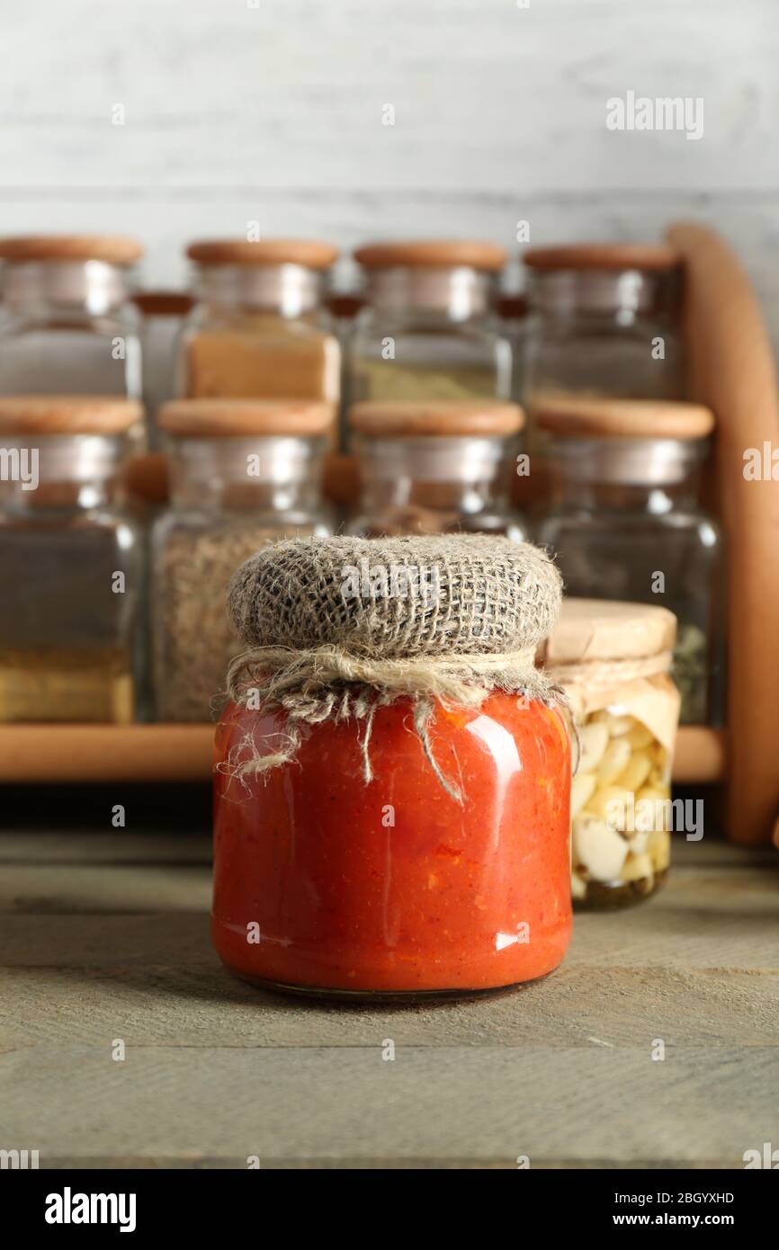 Different spices canned vegetables in glass bottles on stand with ...