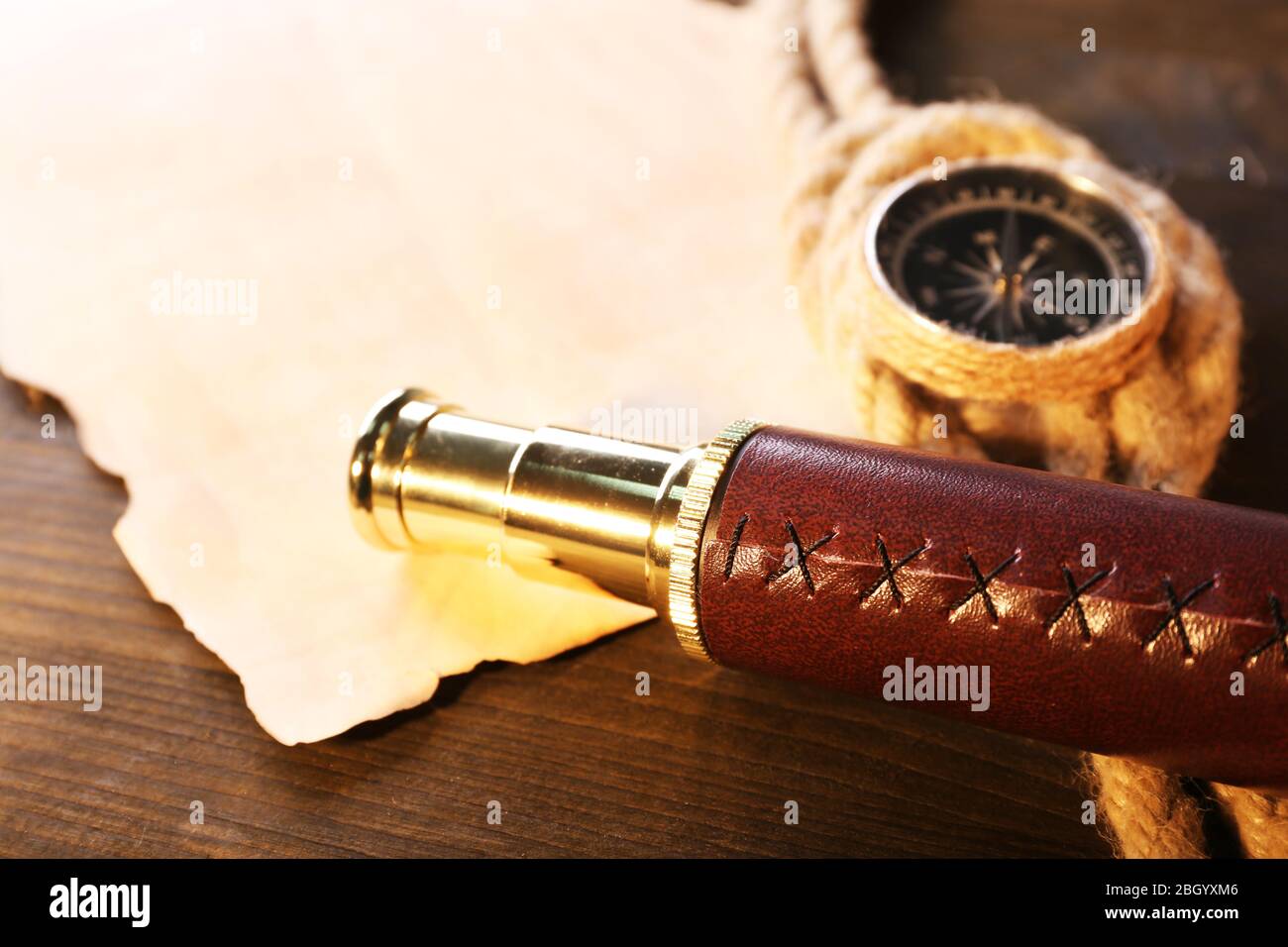 Marine still life spyglass, compass rope and sheet of paper on wooden ...