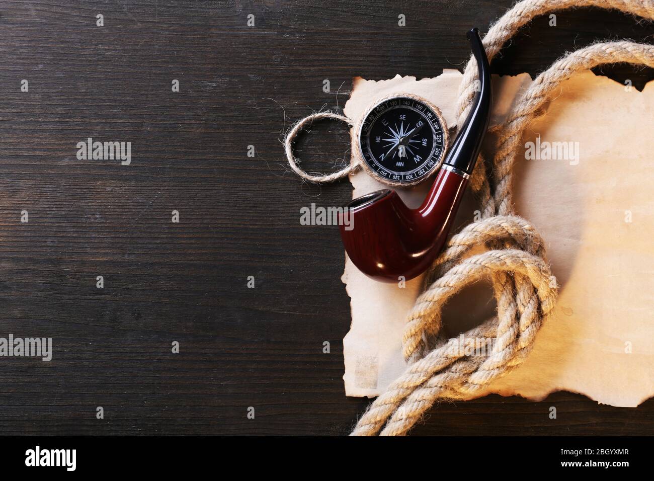 Marine still life pipe, compass, rope and sheet of paper on wooden ...
