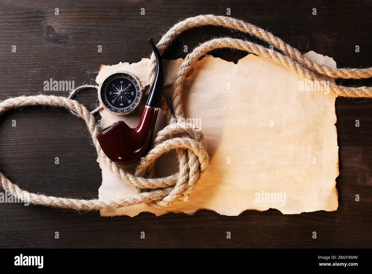 Marine still life pipe, compass, rope and sheet of paper on wooden ...