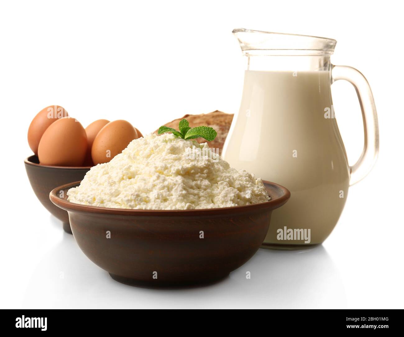 Dairy products in pottery,eggs and glass jug of milk isolated on white ...