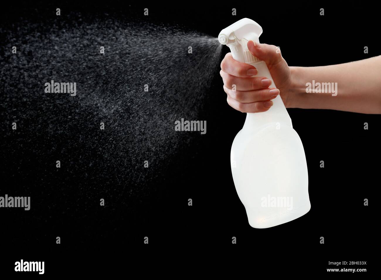Male hand spraying water on black background Stock Photo - Alamy