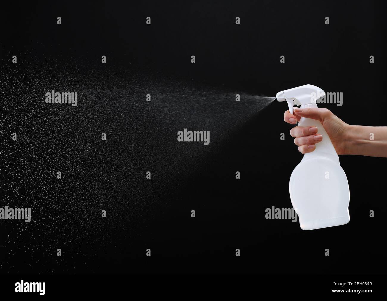 Male hand spraying water on black background Stock Photo - Alamy