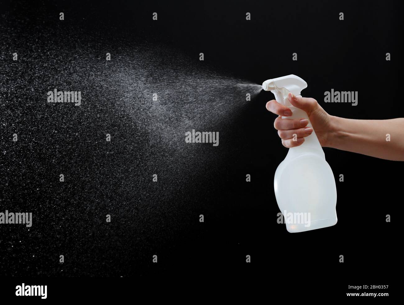 Male hand spraying water on black background Stock Photo - Alamy