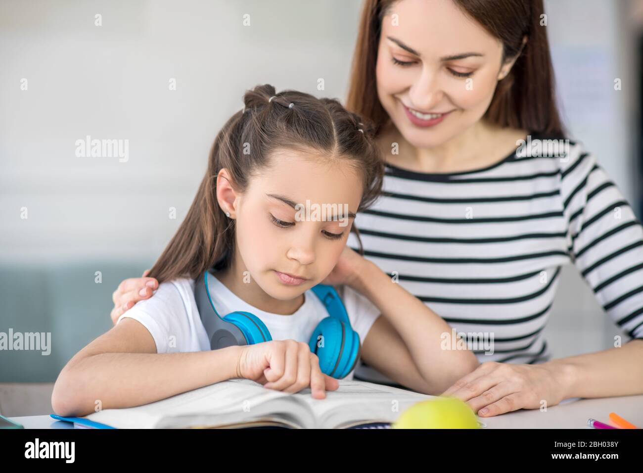 Mom reading a textbook with her daughter Stock Photo - Alamy