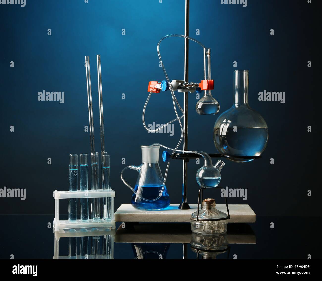 Fixed laboratory glassware on support on dark colorful background Stock ...