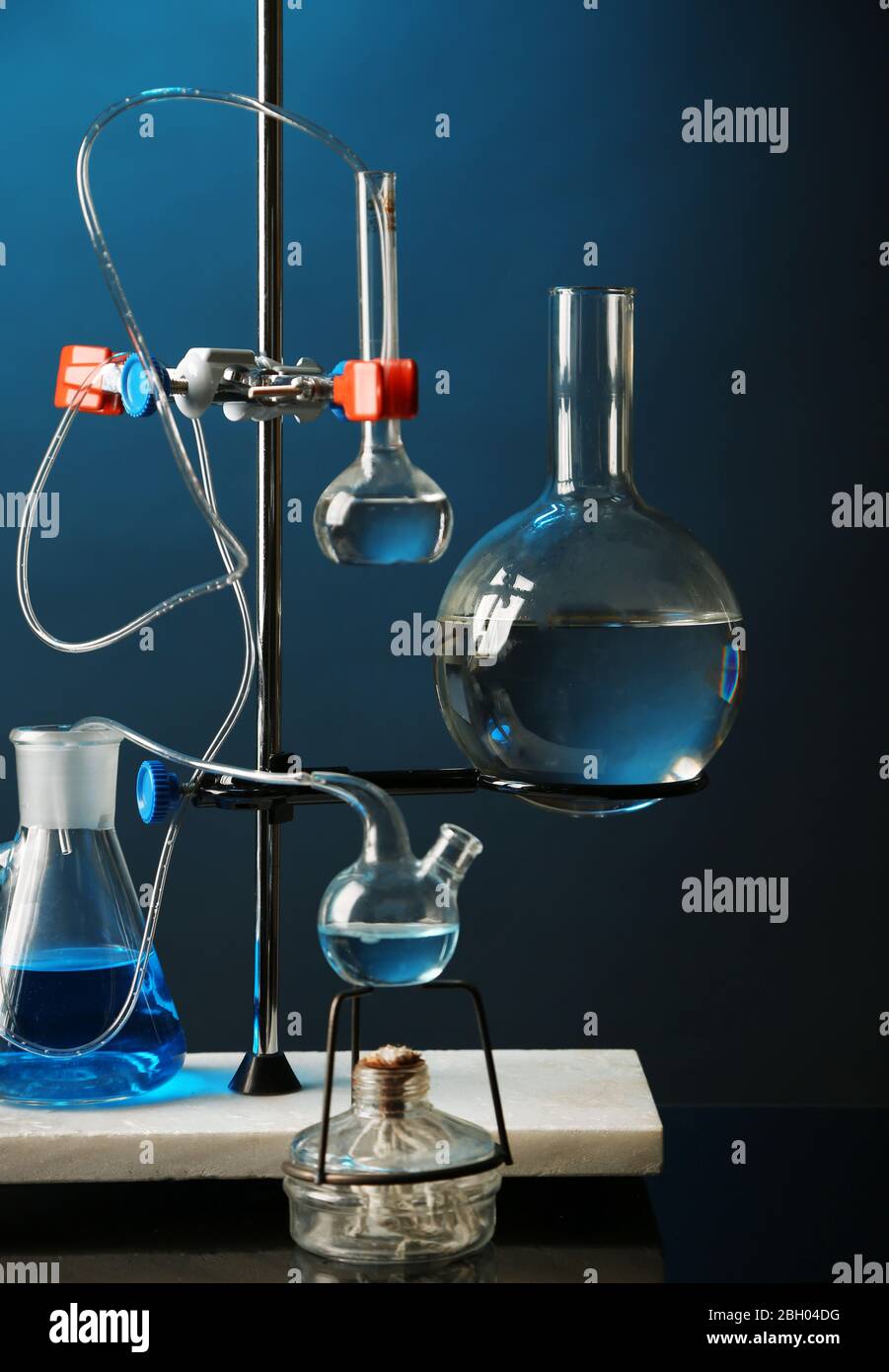 Fixed laboratory glassware on support on dark colorful background Stock ...