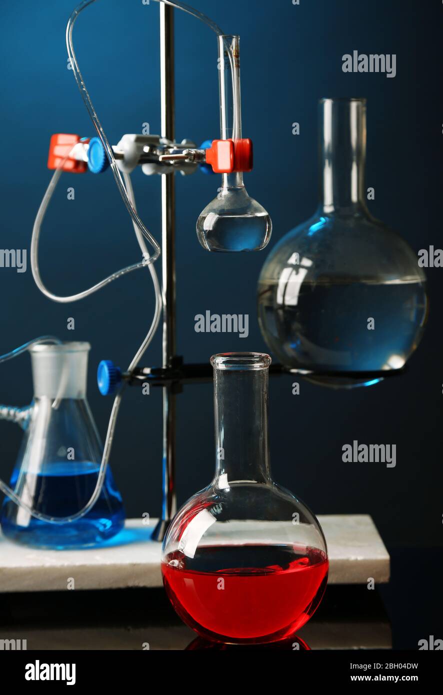 Fixed laboratory glassware on support on dark colorful background Stock ...