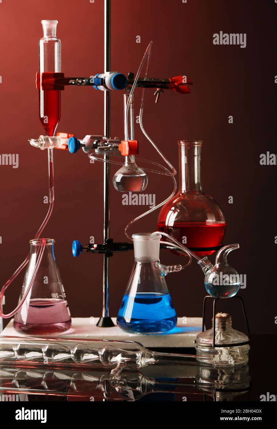 Fixed laboratory glassware on support on dark colorful background Stock ...