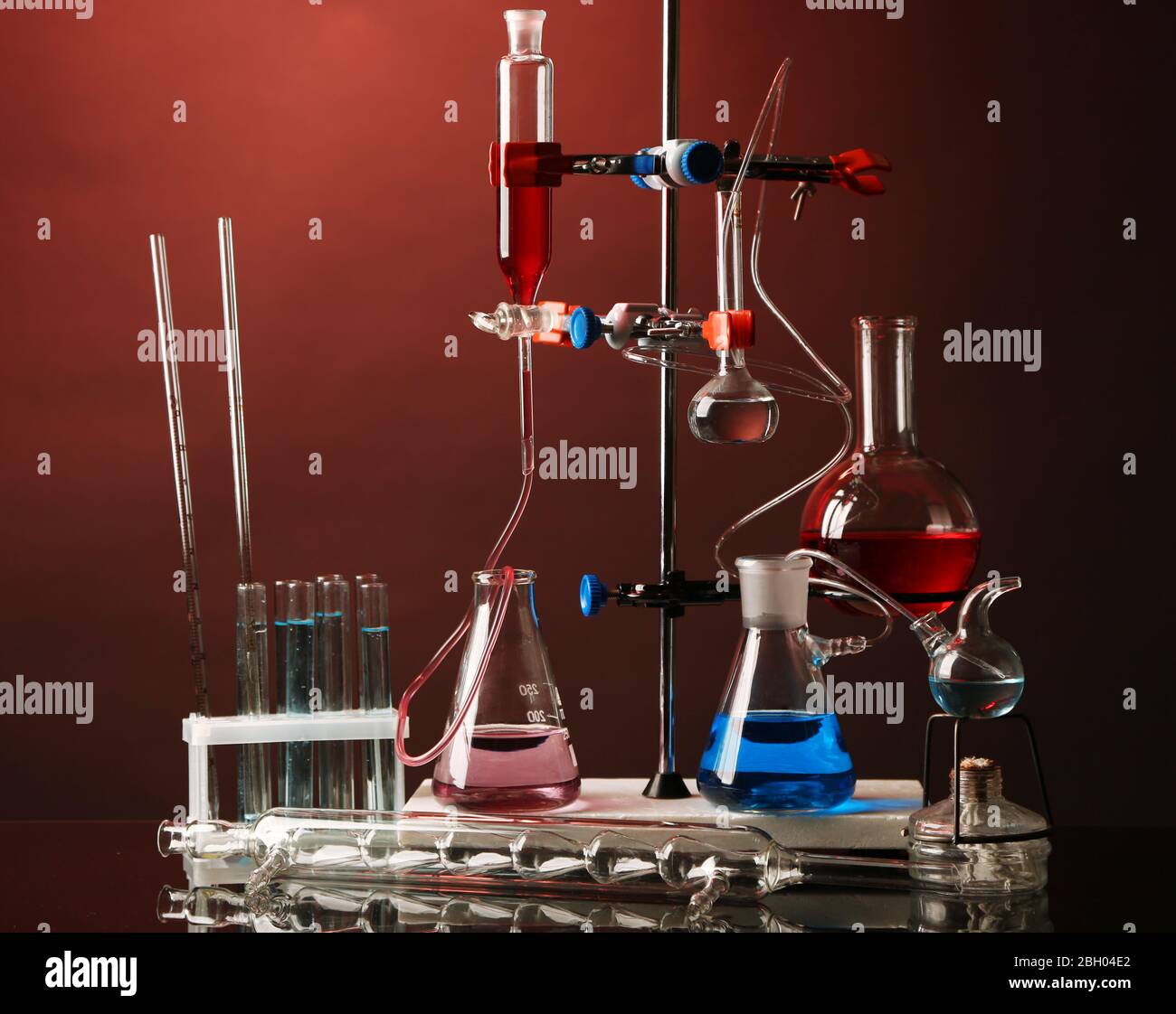 Fixed laboratory glassware on support on dark colorful background Stock ...