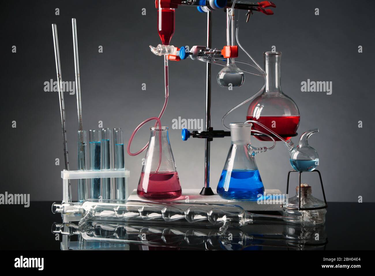 Fixed laboratory glassware on support on dark colorful background Stock ...