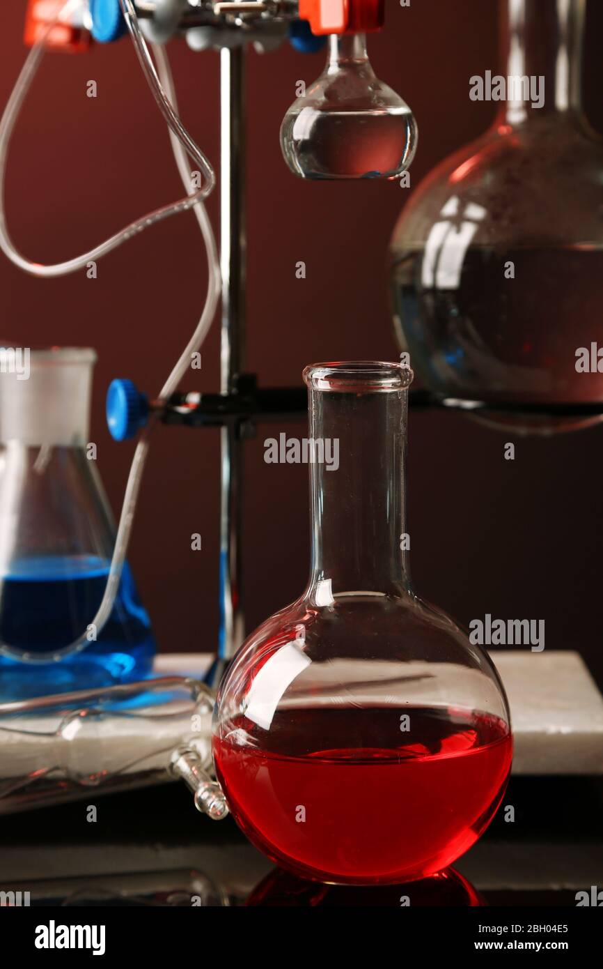Fixed laboratory glassware on support on dark colorful background Stock ...