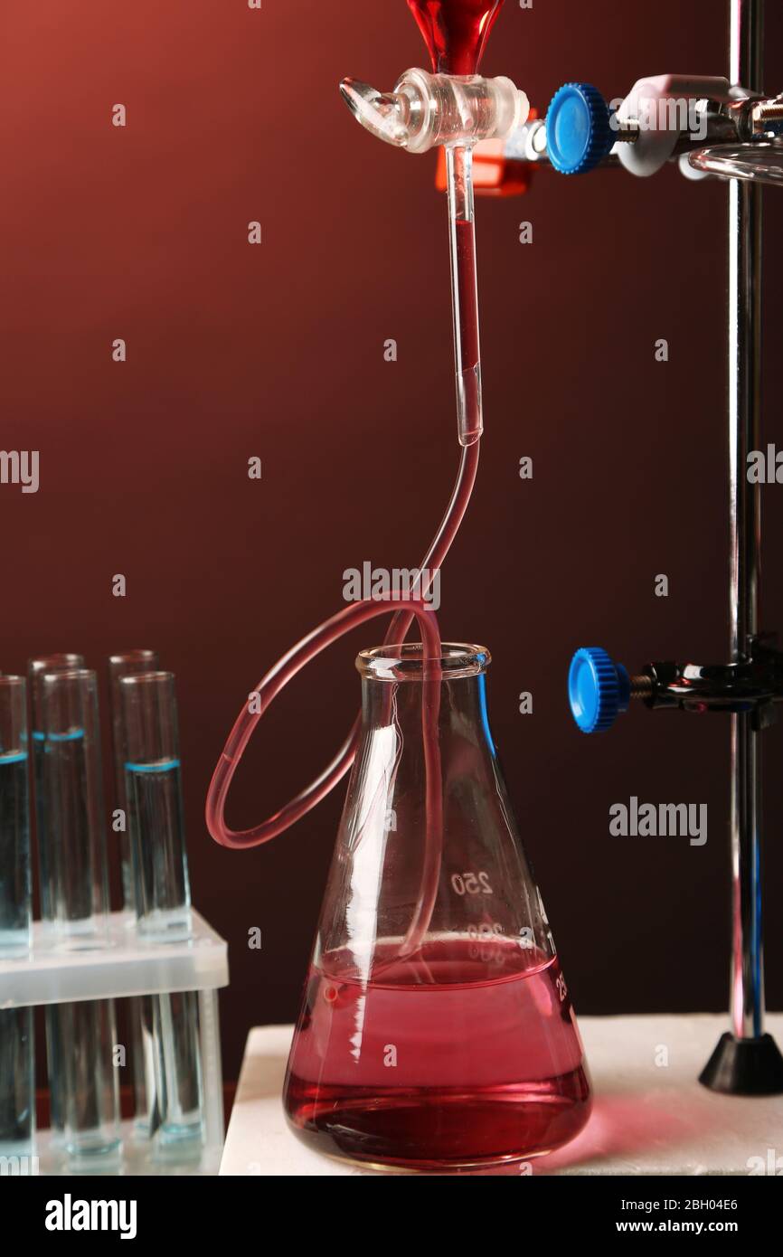 Fixed laboratory glassware on support on dark colorful background Stock ...