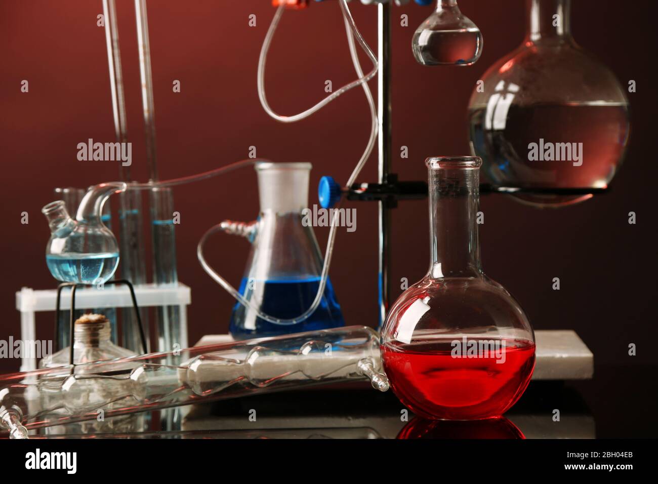Fixed laboratory glassware on support on dark colorful background Stock ...