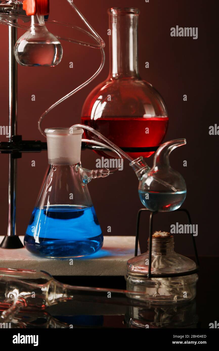 Fixed laboratory glassware on support on dark colorful background Stock ...