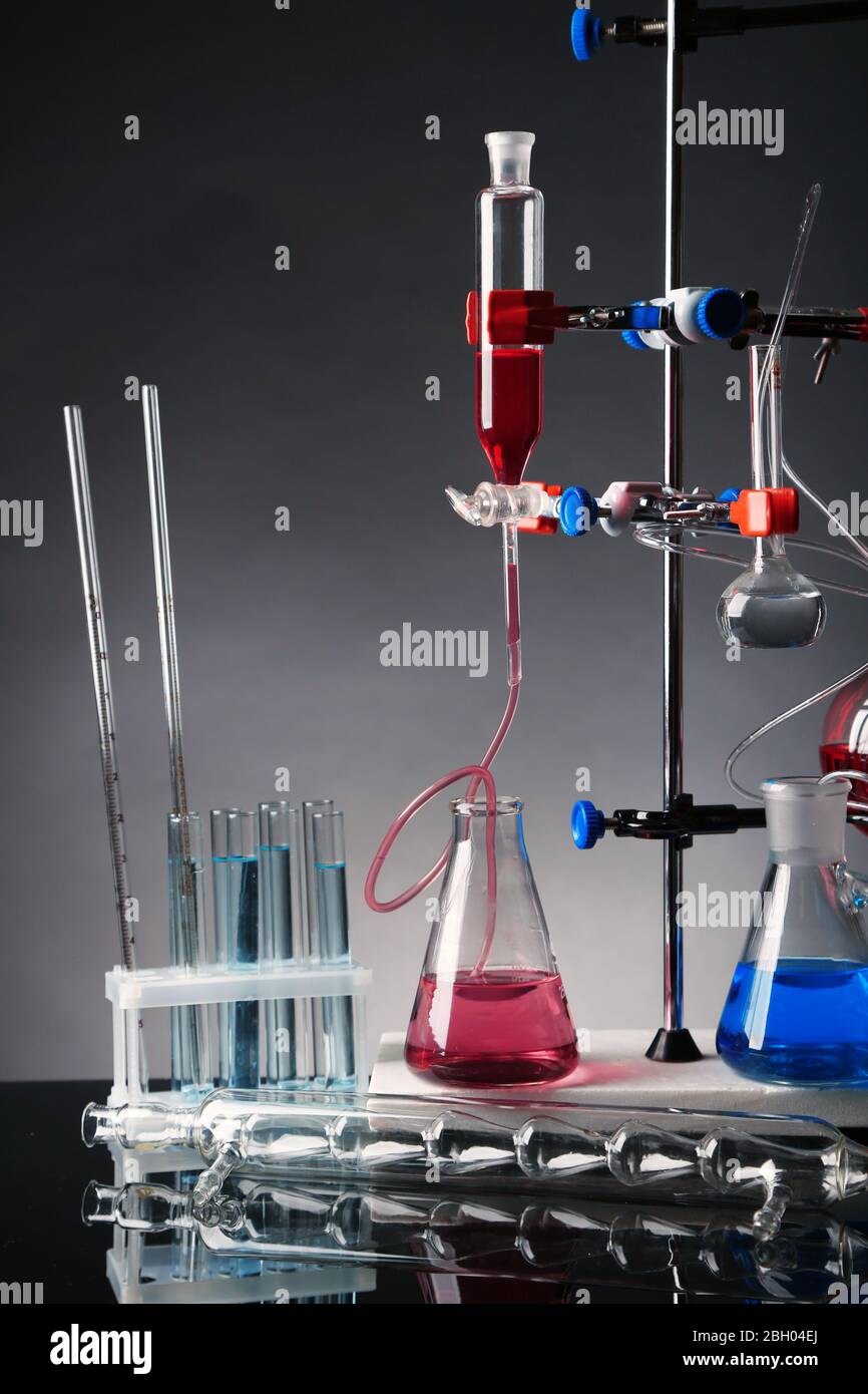 Fixed laboratory glassware on support on dark colorful background Stock ...
