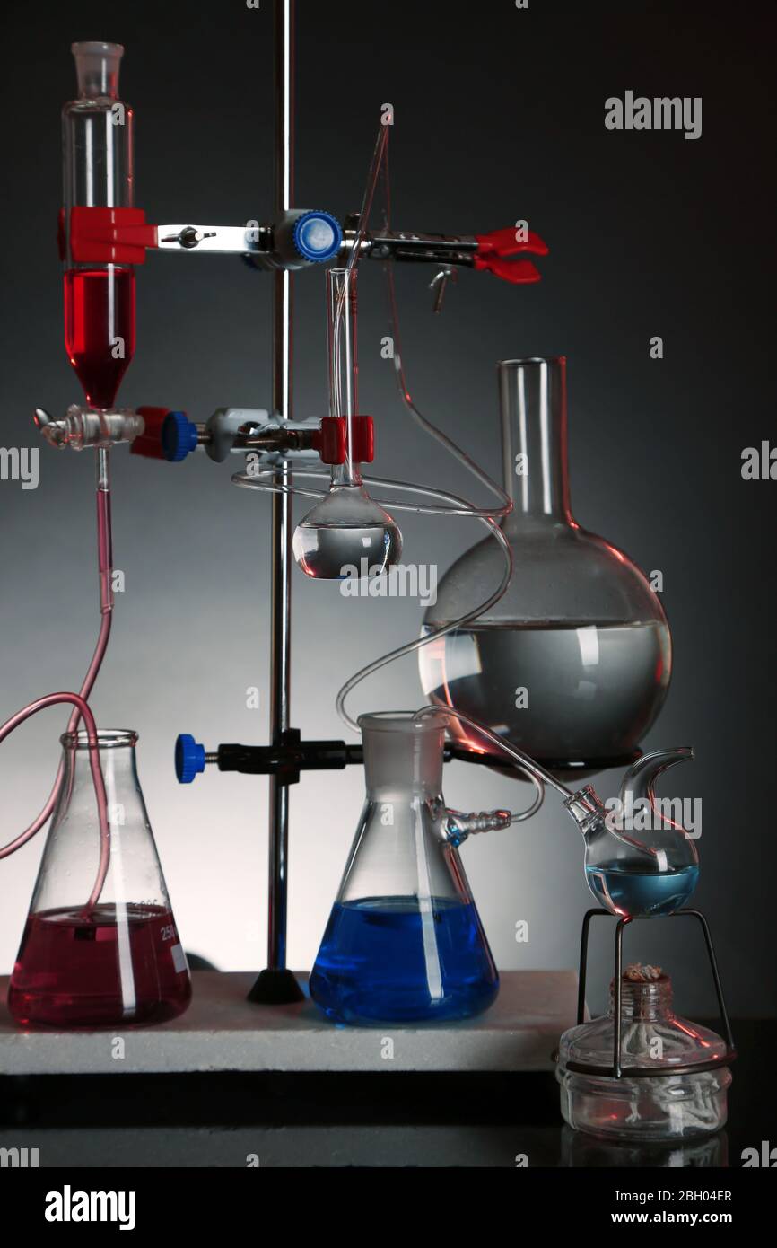 Fixed laboratory glassware on support on dark colorful background Stock ...
