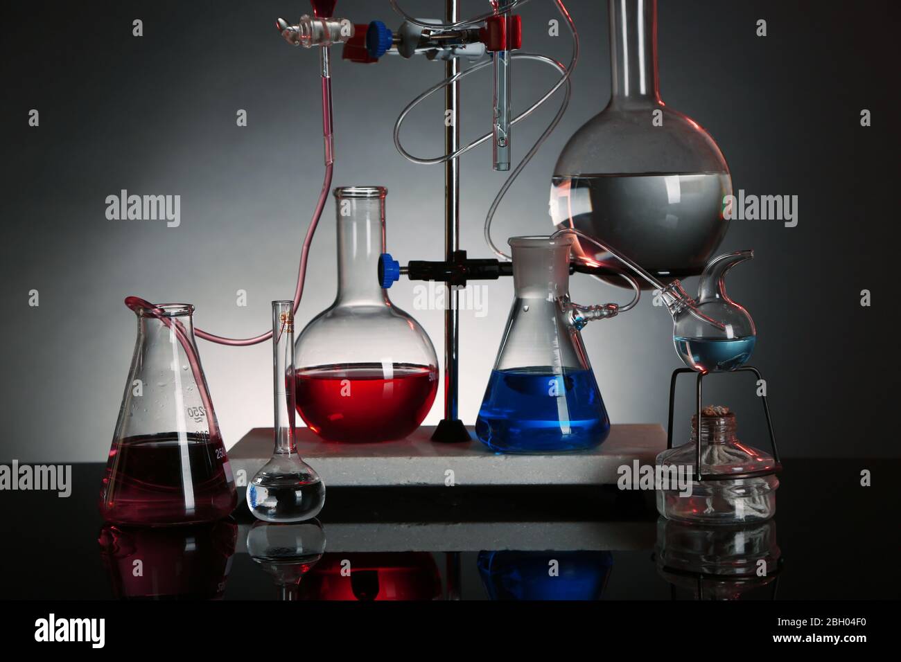 Fixed laboratory glassware on support on dark colorful background Stock ...